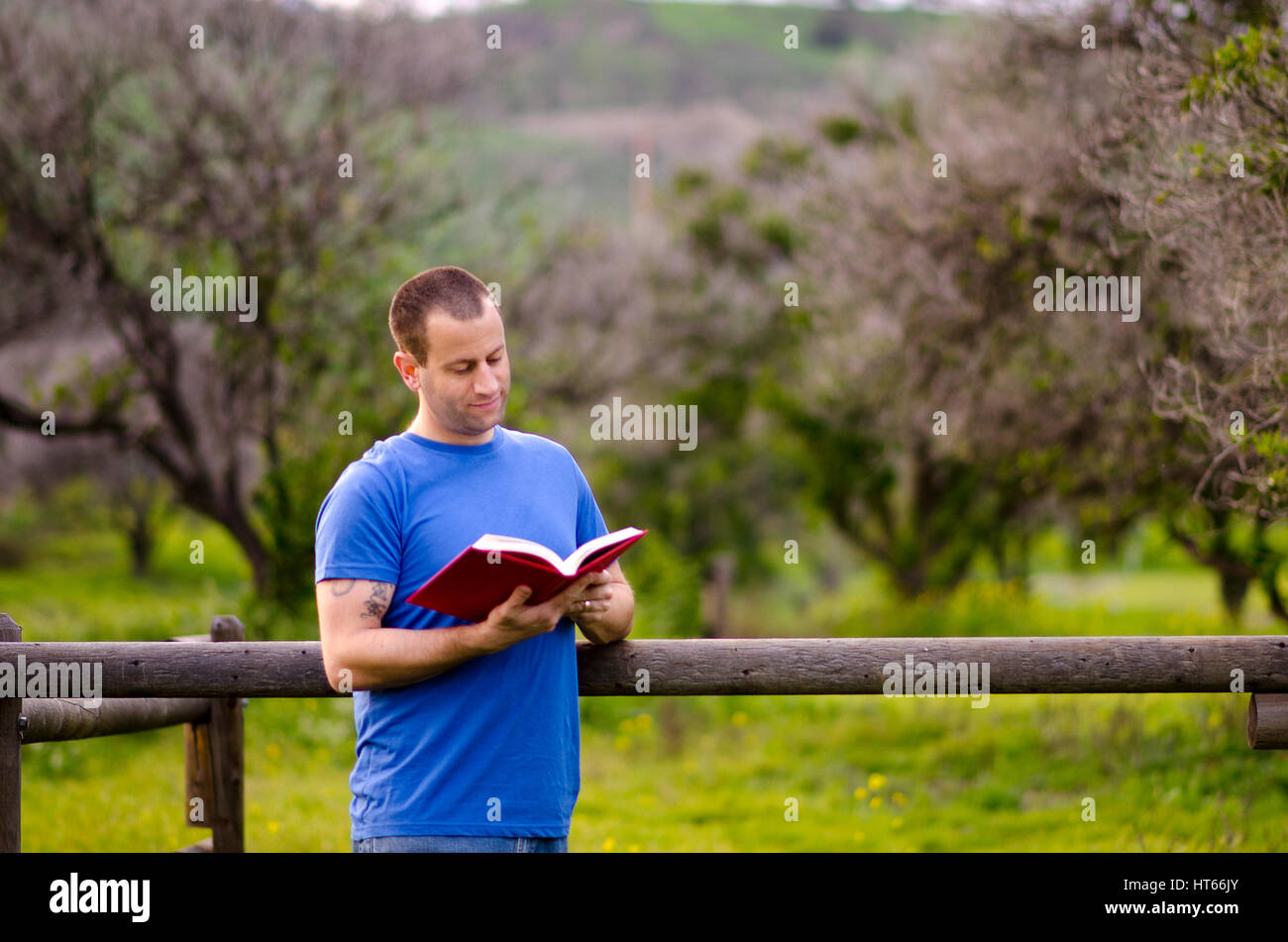 Man reading a book outside in a rural environment Stock Photo - Alamy