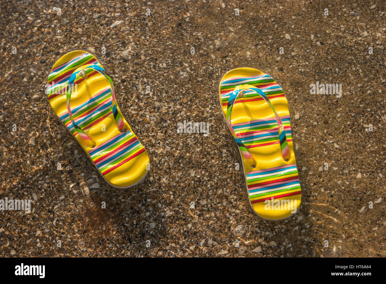 Flip flops on the shore. Transparent water with sand. Summer holidays ...