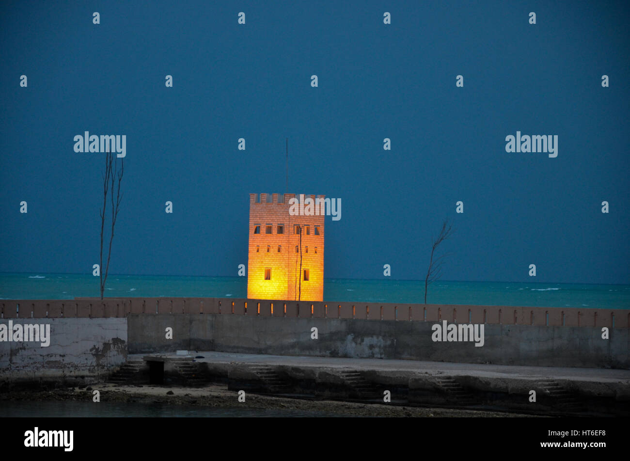 Brightly lit tower against blue sky backdrop at Al Ghariyah Resort ...