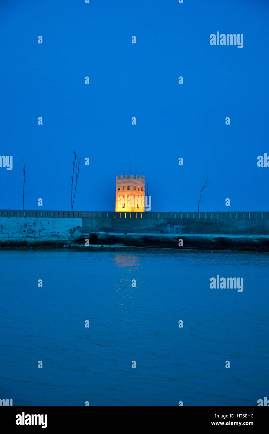 Brightly lit tower against blue sky backdrop at Al Ghariyah Resort ...