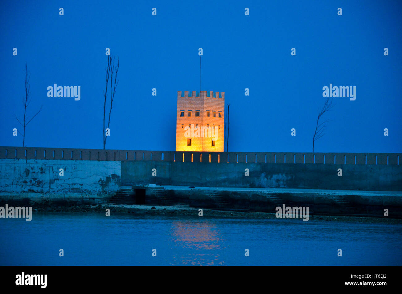 Brightly lit tower against blue sky backdrop at Al Ghariyah Resort ...