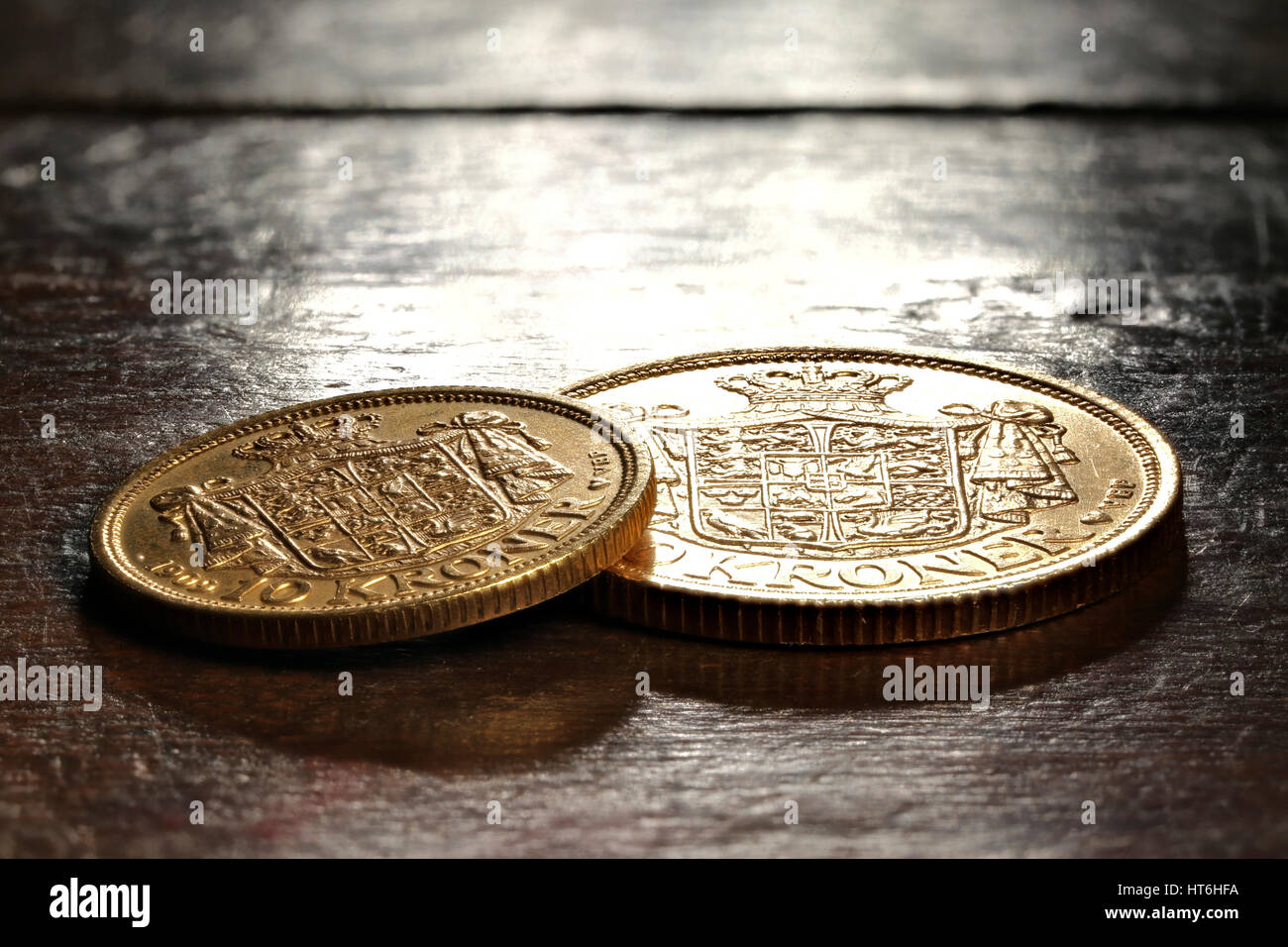 Danish gold coins on rustic wooden background Stock Photo - Alamy
