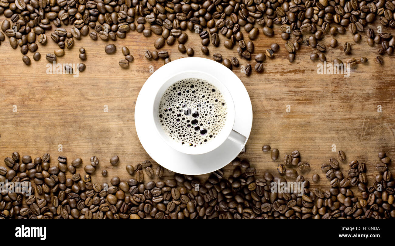 coffee beams background with cup on rustic wooden table Stock Photo - Alamy