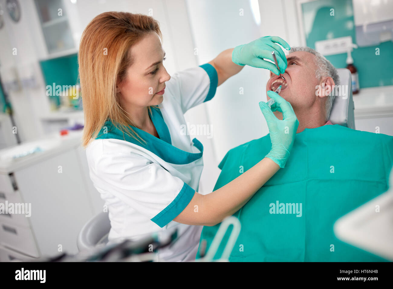Senior male patient receiving anesthesia with syringe in dental clinic ...