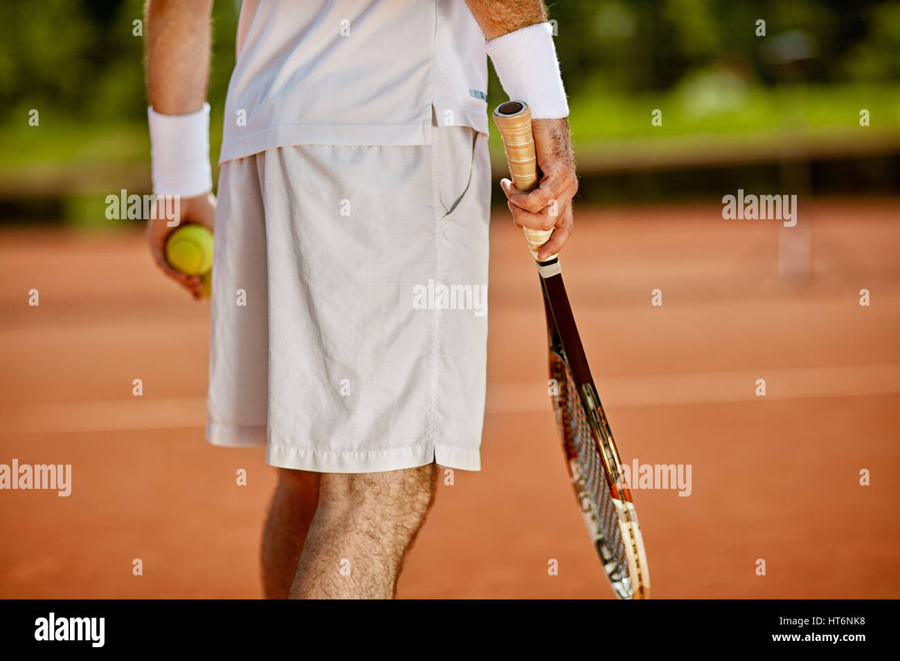 Tennis player on court with racket and ball - body part, back view ...