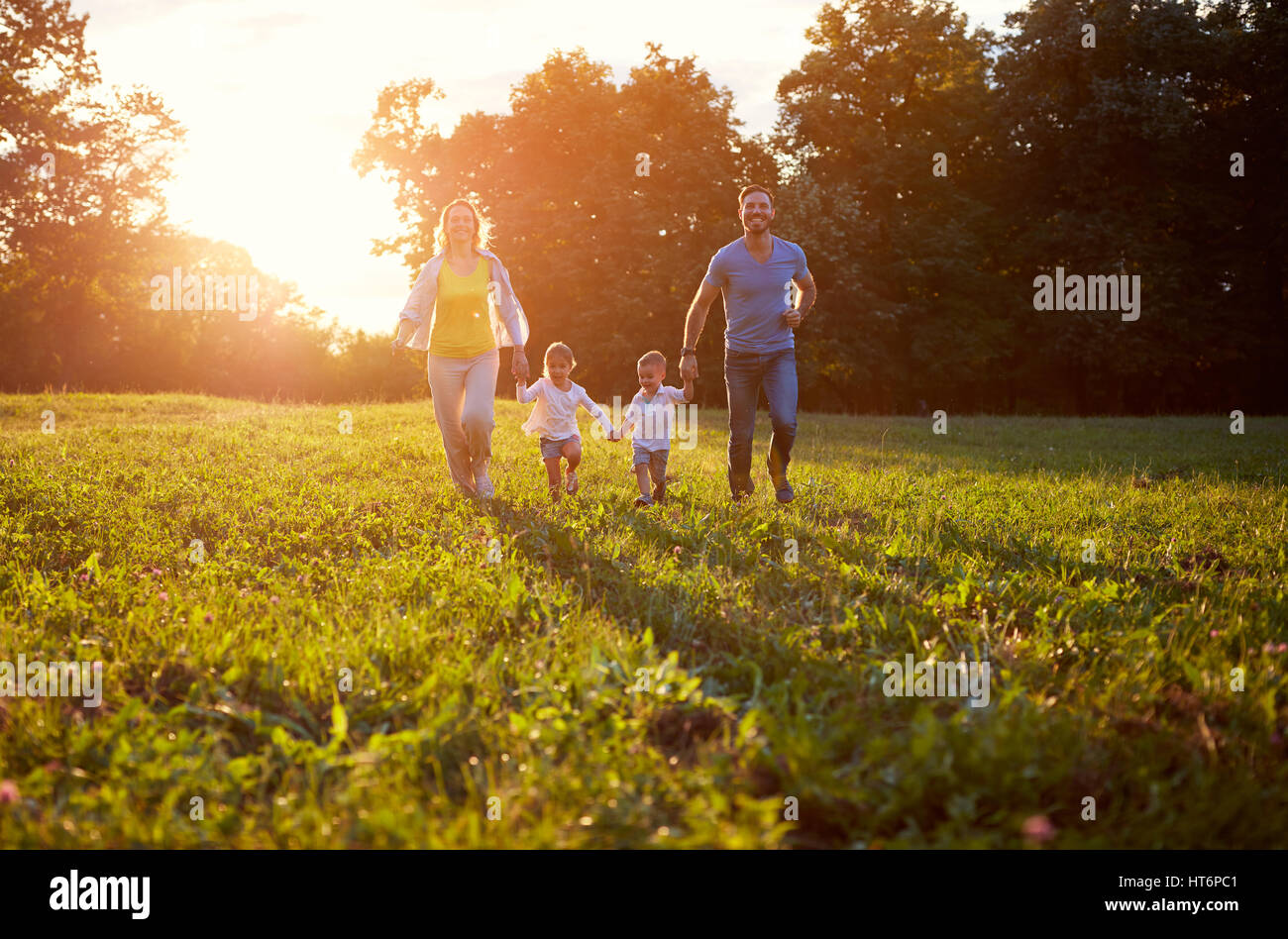 Family with children run together in nature Stock Photo - Alamy