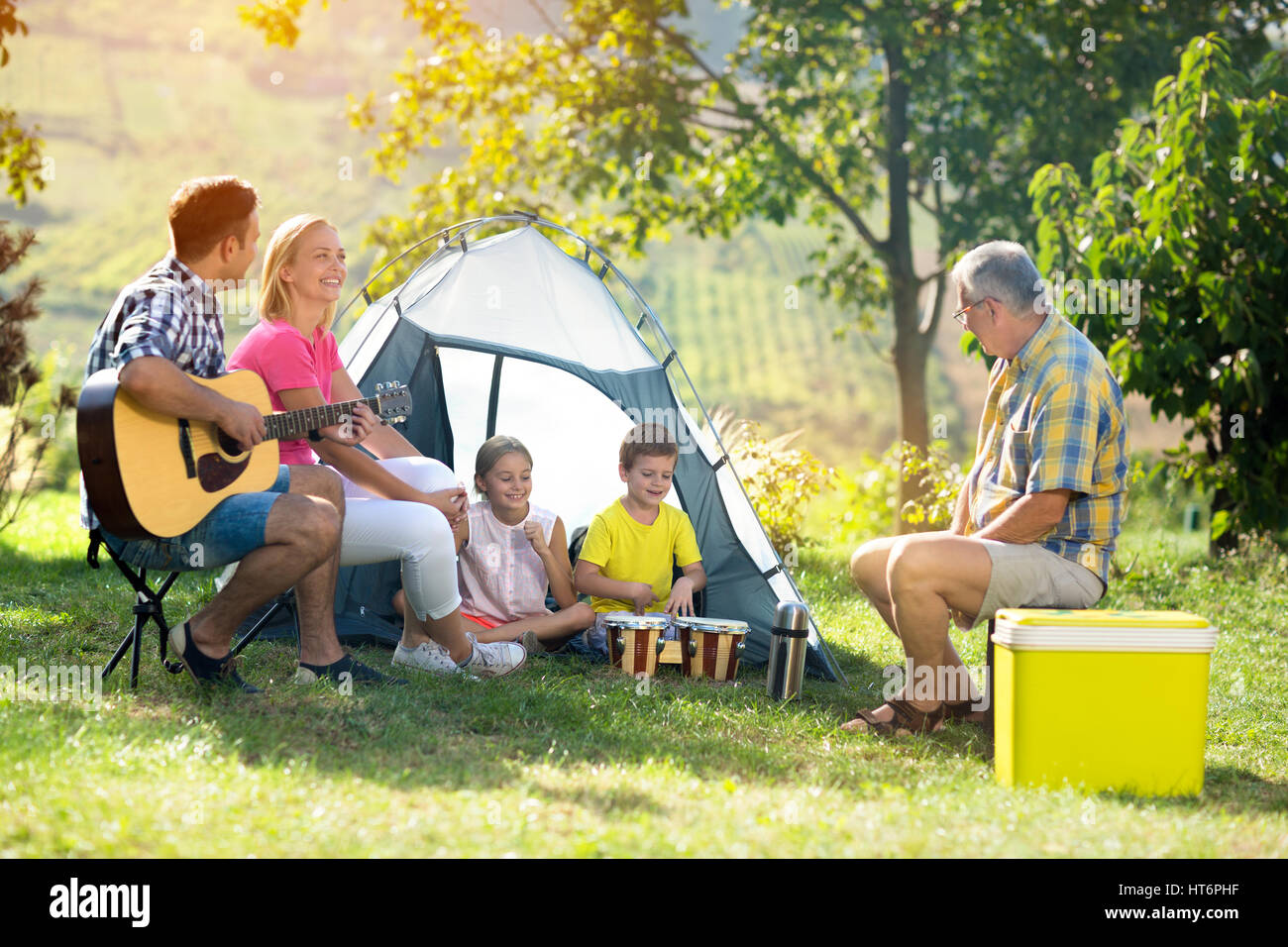 Happy family enjoying picnic at camping Stock Photo - Alamy