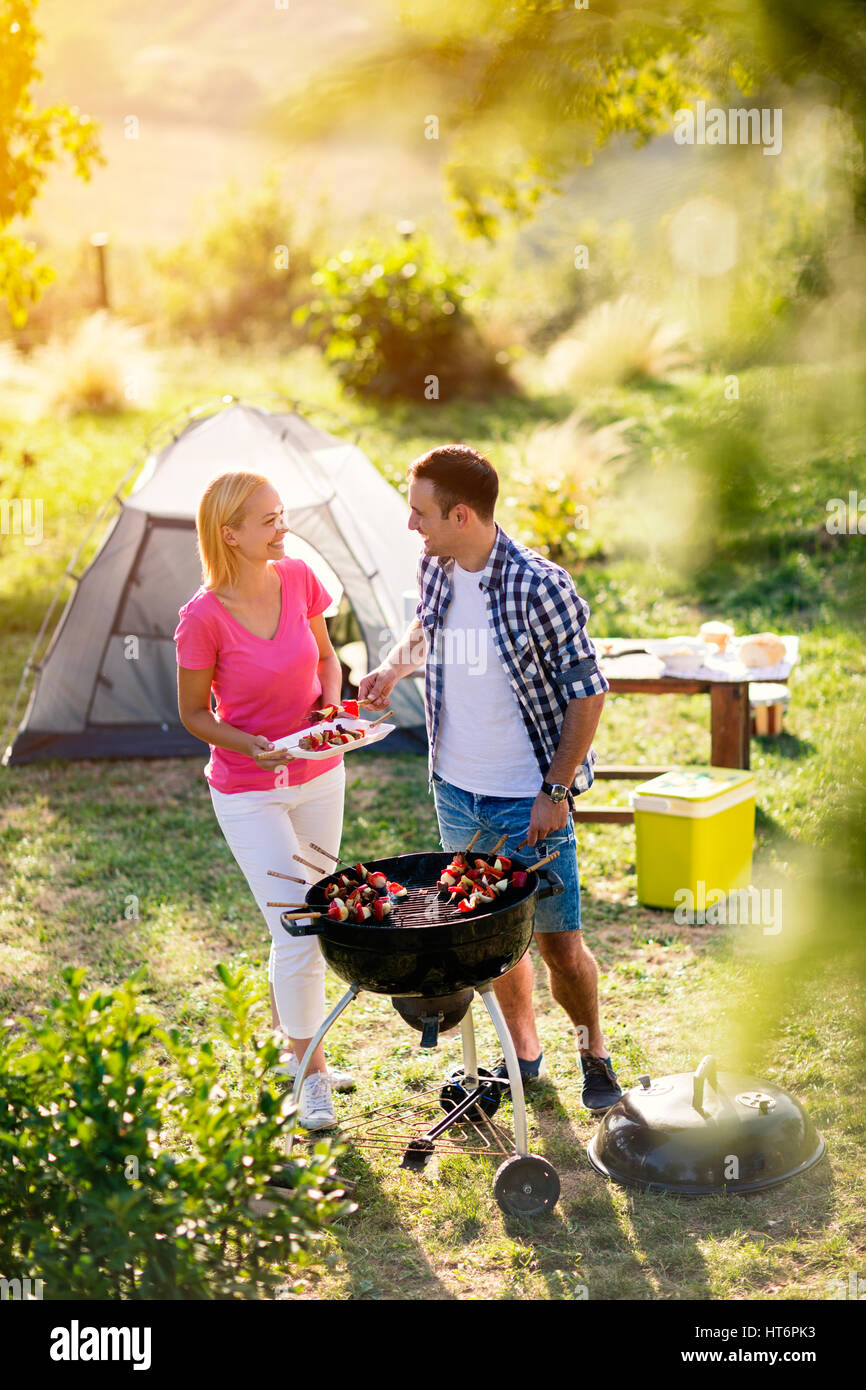 Happy couple grilling meat on a barbecue Stock Photo - Alamy