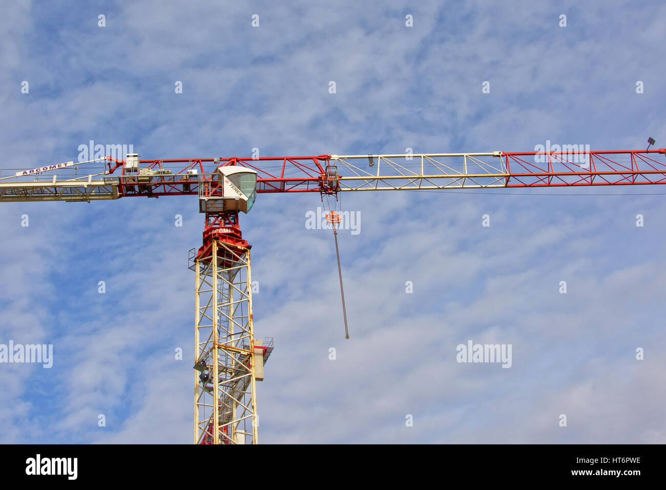 White and red construction crane against cloudy background with copy ...