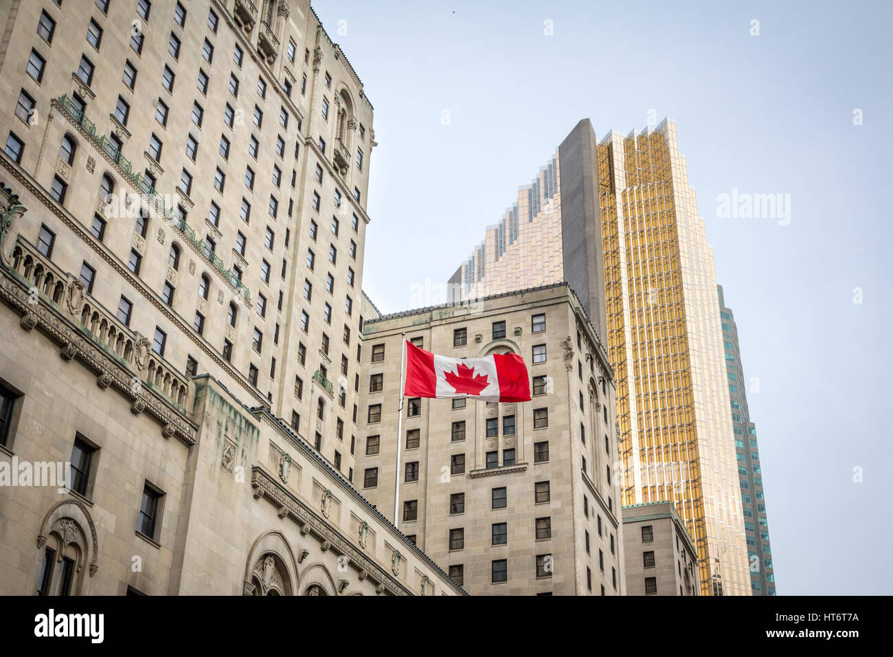 Canadian flag in front of a business building and an older skyscraper ...