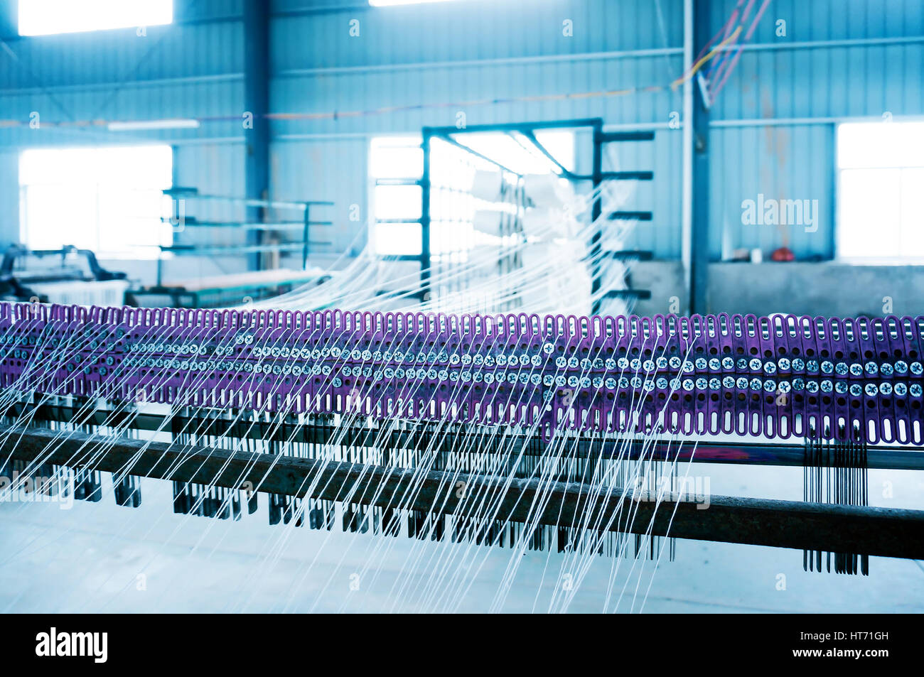 A row of textile looms weaving cotton yarn in a textile mill Stock ...