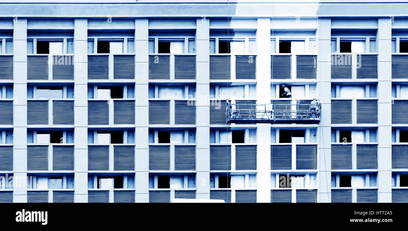 Workers painting the facade of the building, blue tone image Stock ...