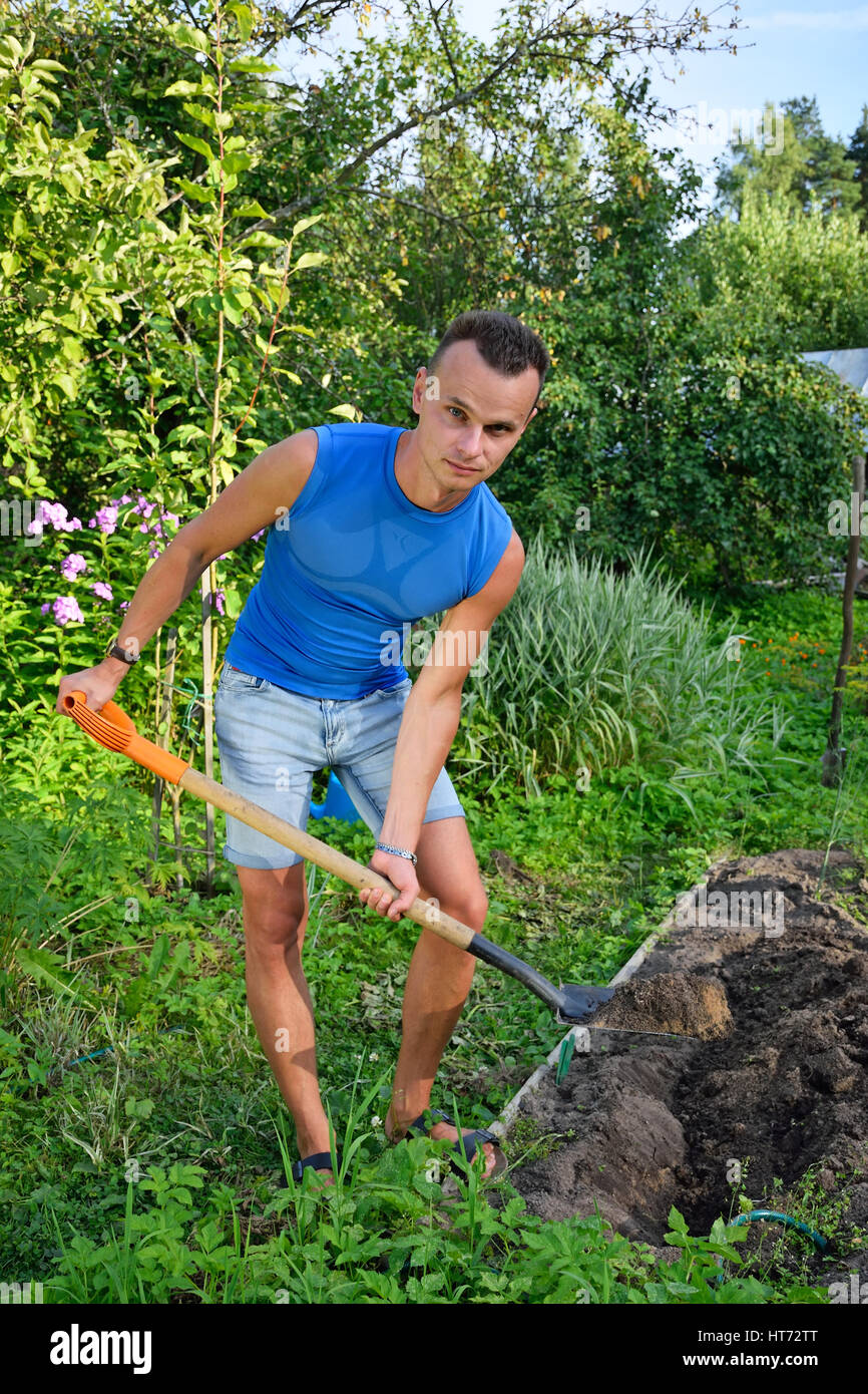 A young man digging on the plot in the summer on a Sunny day Stock ...