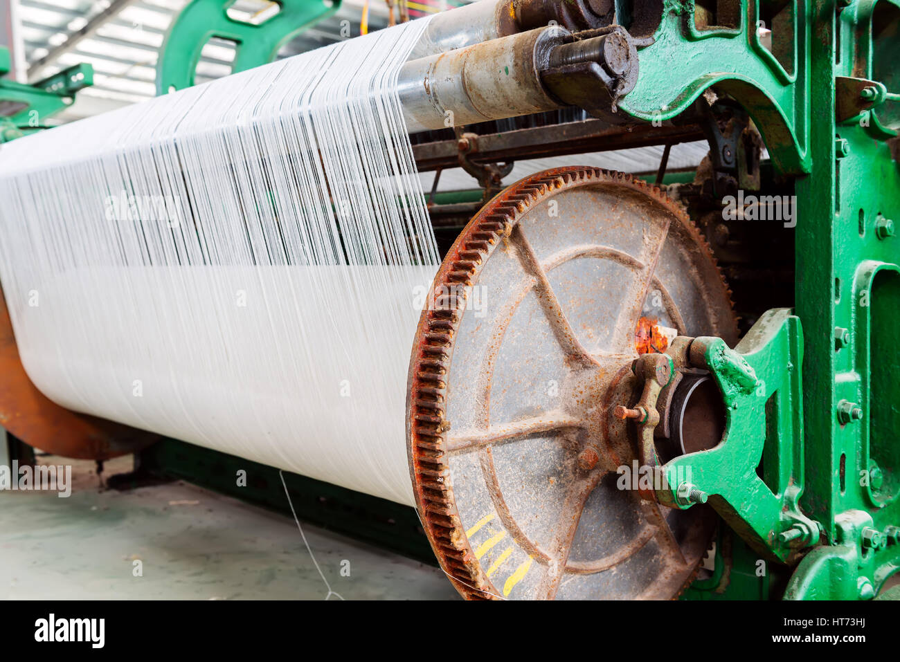 A row of textile looms weaving cotton yarn in a textile mill Stock ...
