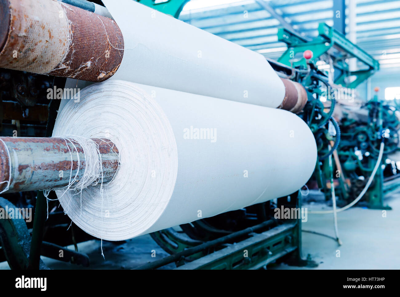 A row of textile looms weaving cotton yarn in a textile mill Stock ...