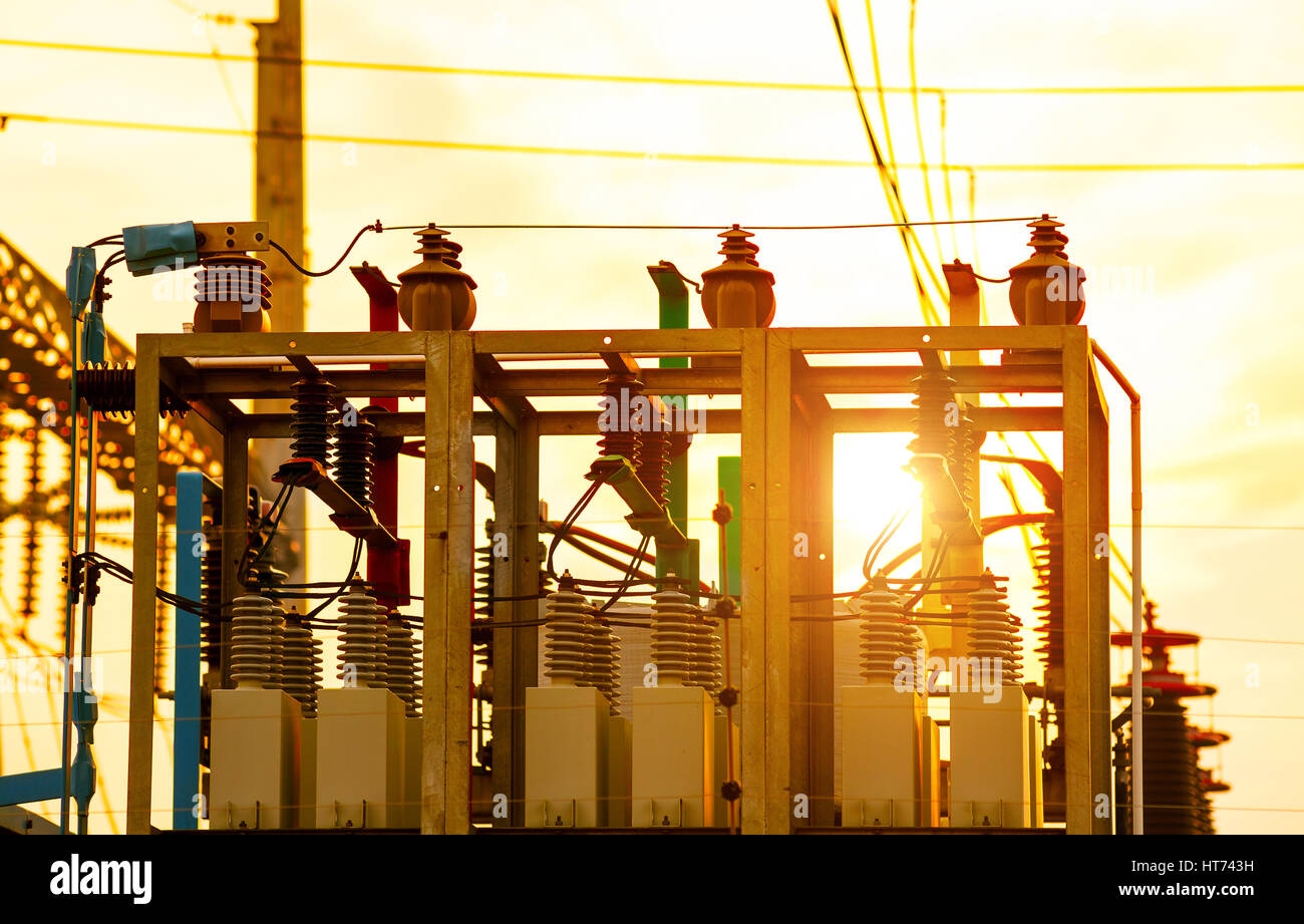 Close-up of high-voltage power substation equipment, evening landscape ...