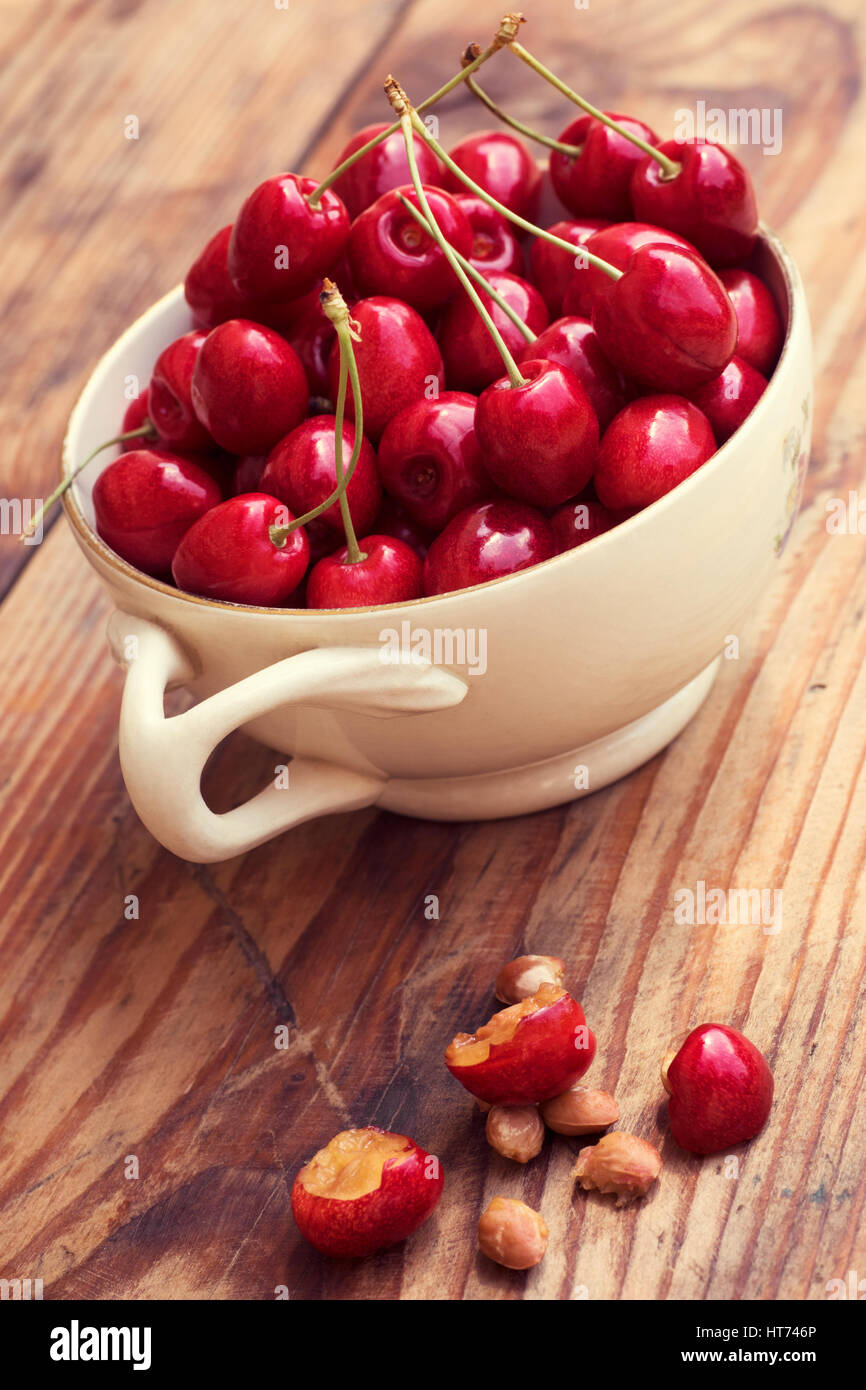 Ripe organic homegrown cherries and stones in a vintage ceramic bowl ...