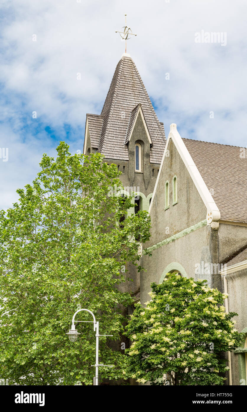 Traditional old grey church steeple beyond green trees Stock Photo - Alamy