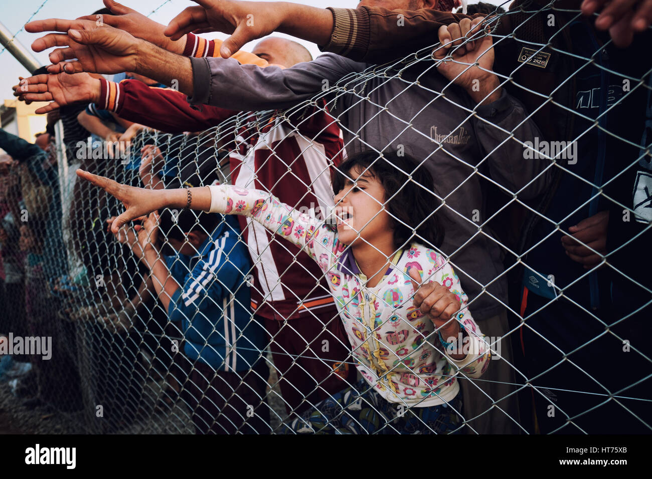 a young girl begging for clothes at refugee camp after fleeing fighting ...