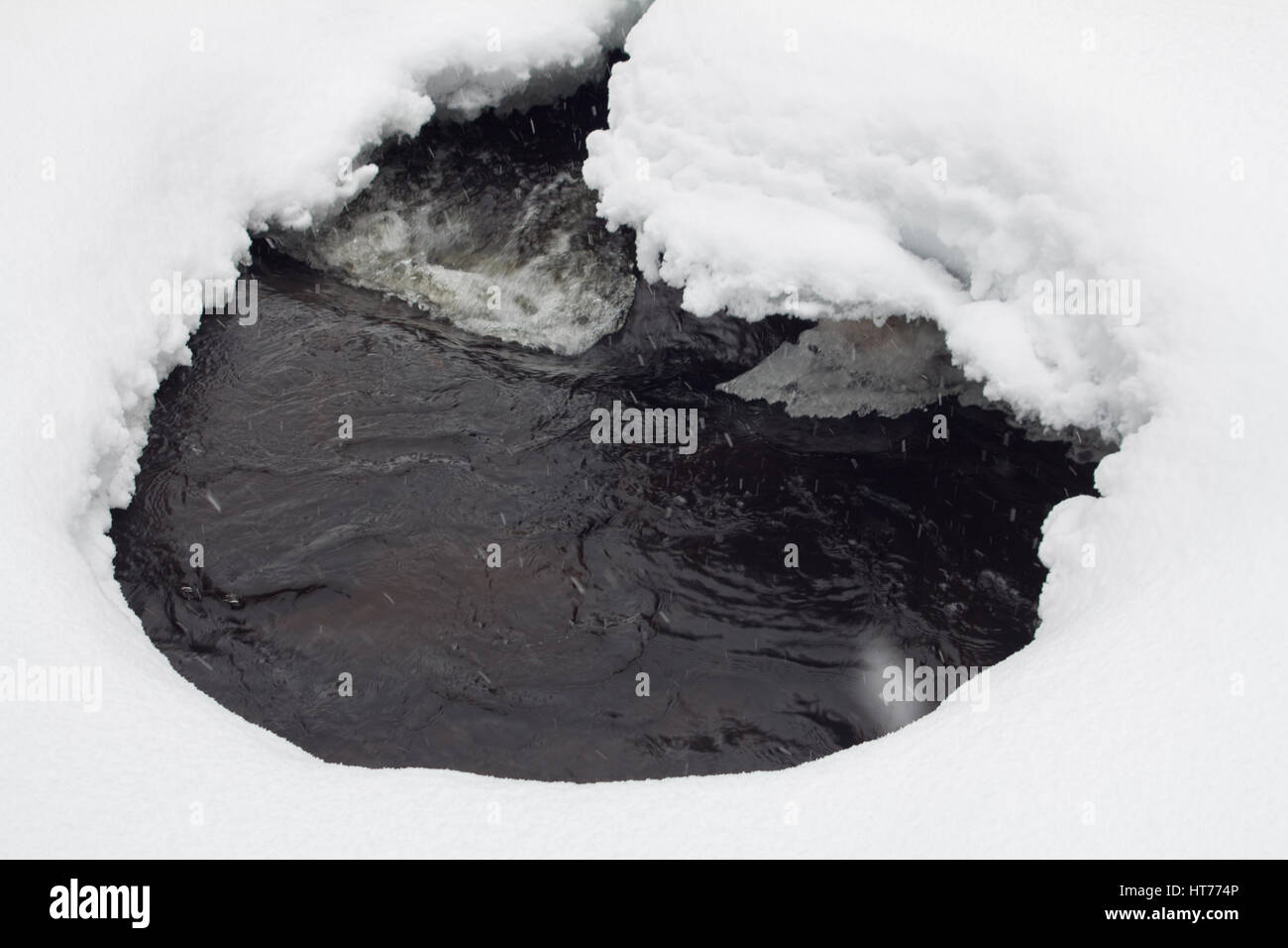 Snowing over frozen river, snow bridges Stock Photo - Alamy