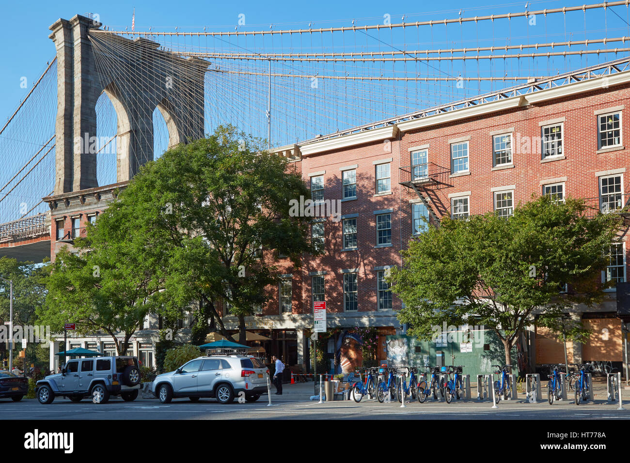Brooklyn Bridge pillar with red bricks buildings facades in a sunny ...