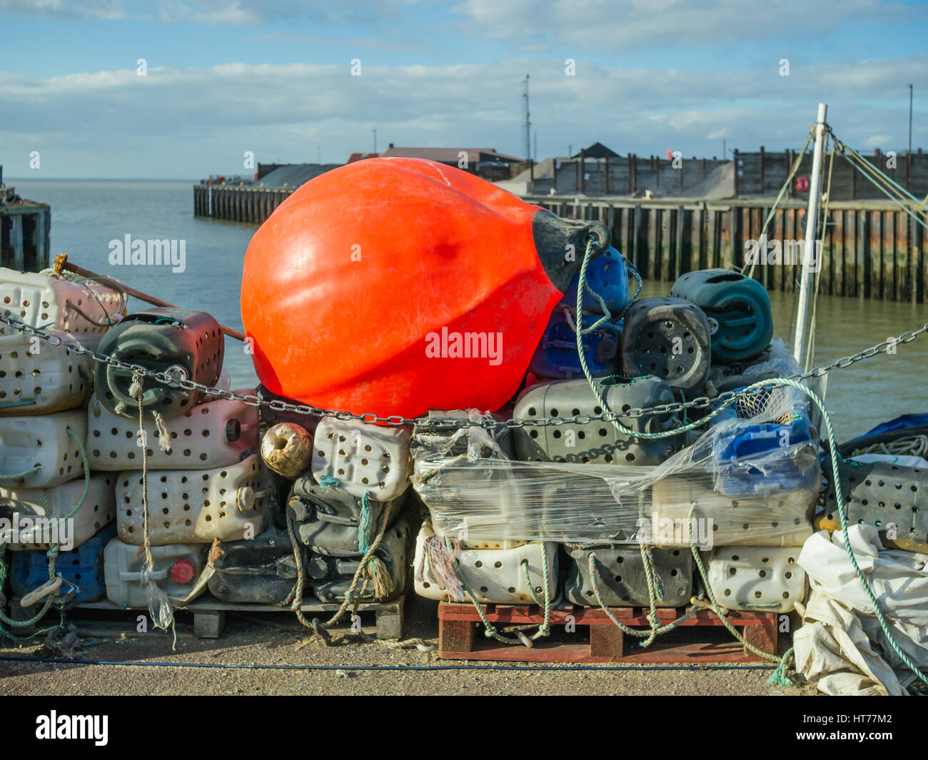 A large bright orange buoy on home made fishing canisters punctured ...