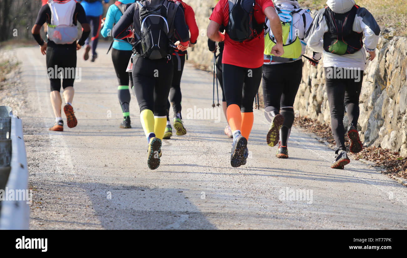 many runners running street photographed from behind and seems to slip ...