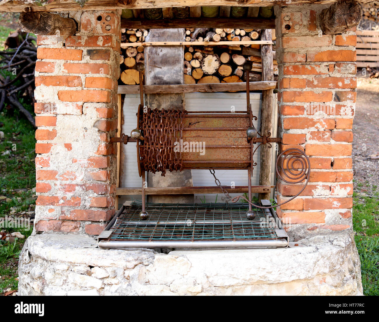 old well in stonework with rusty chain to collect water with the bucket ...