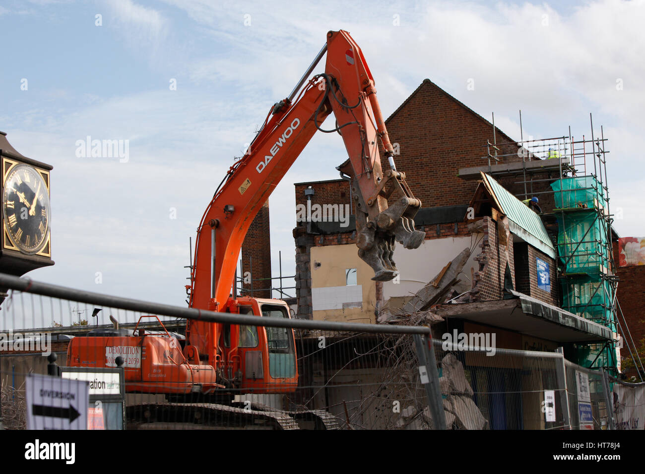 Heavy machinery at work on a demolition site. Tearing down old shops ...
