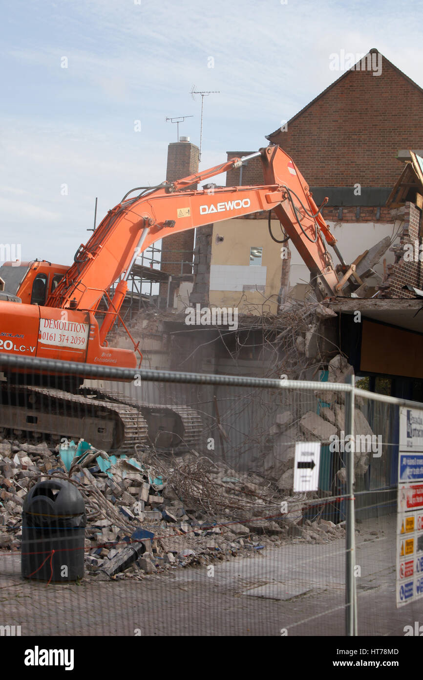 Heavy machinery at work on a demolition site. Tearing down old shops ...