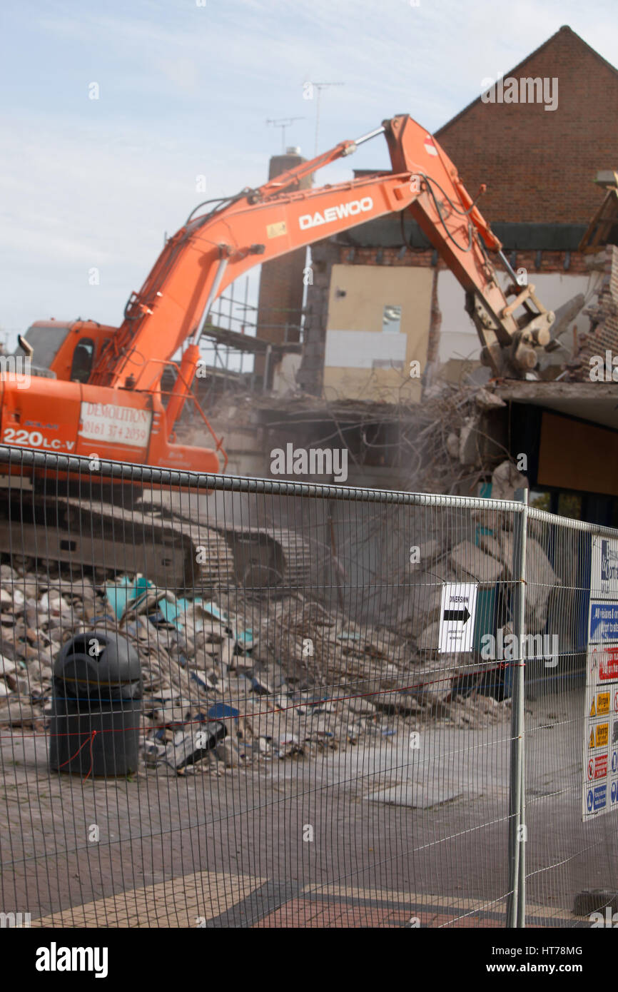 Heavy machinery at work on a demolition site. Tearing down old shops ...