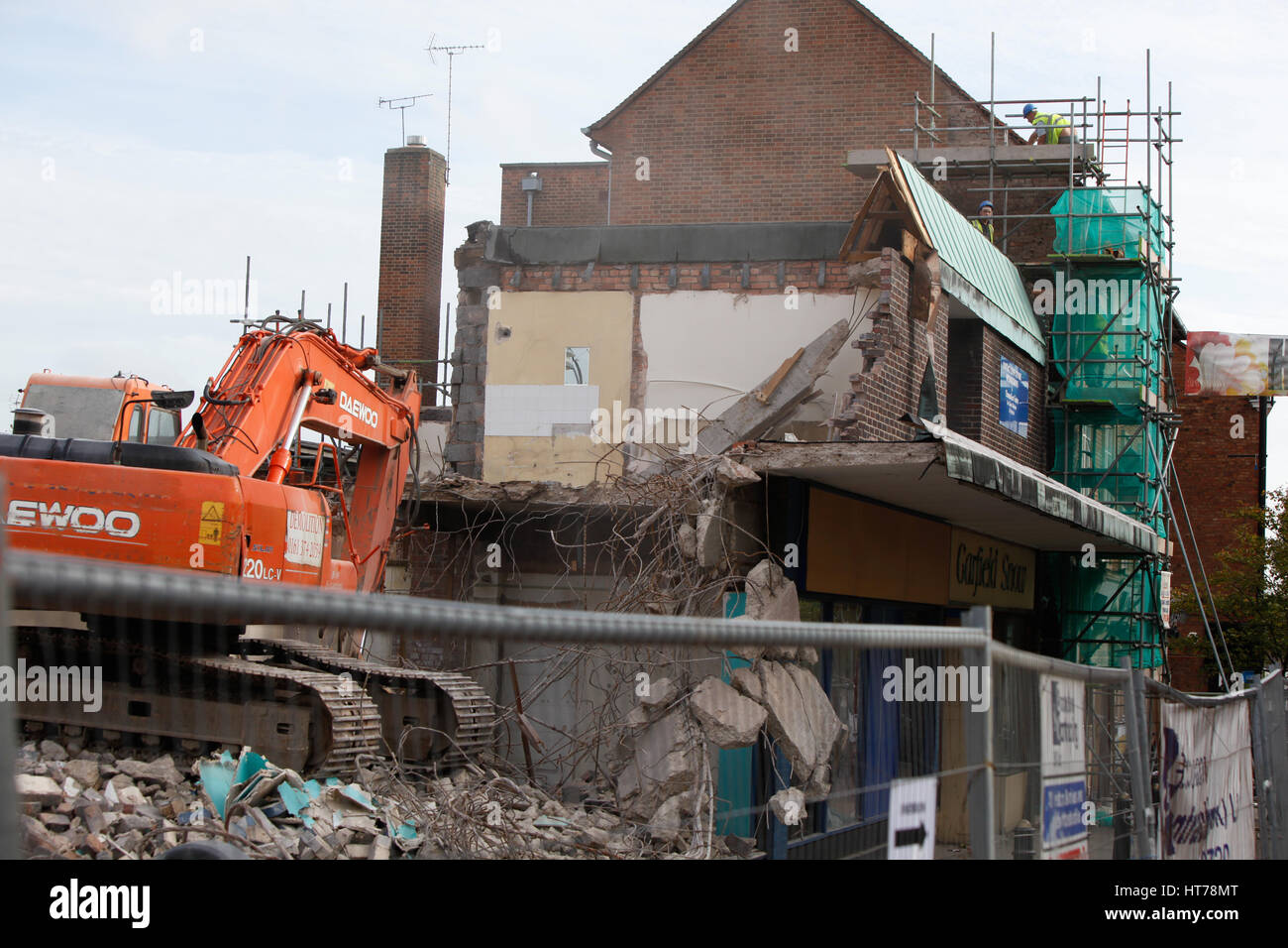 Heavy machinery at work on a demolition site. Tearing down old shops ...