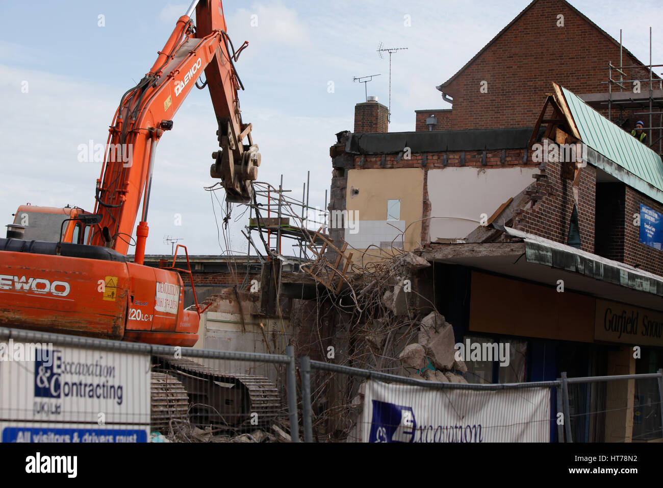 Heavy machinery at work on a demolition site. Tearing down old shops ...