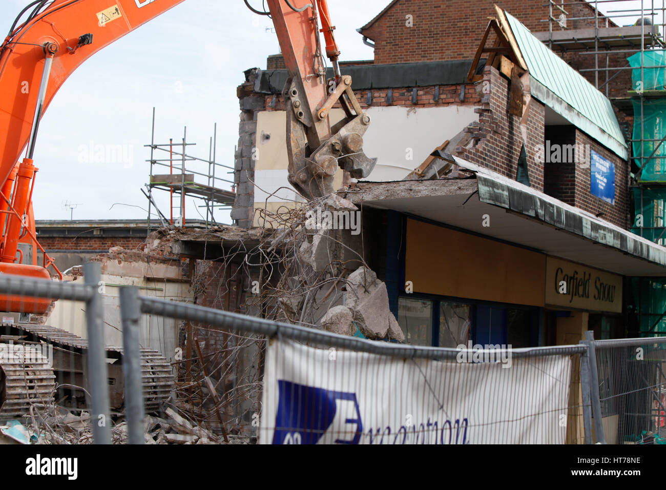 Heavy machinery at work on a demolition site. Tearing down old shops ...