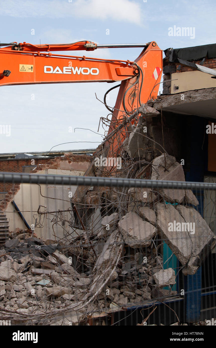 Heavy machinery at work on a demolition site. Tearing down old shops ...