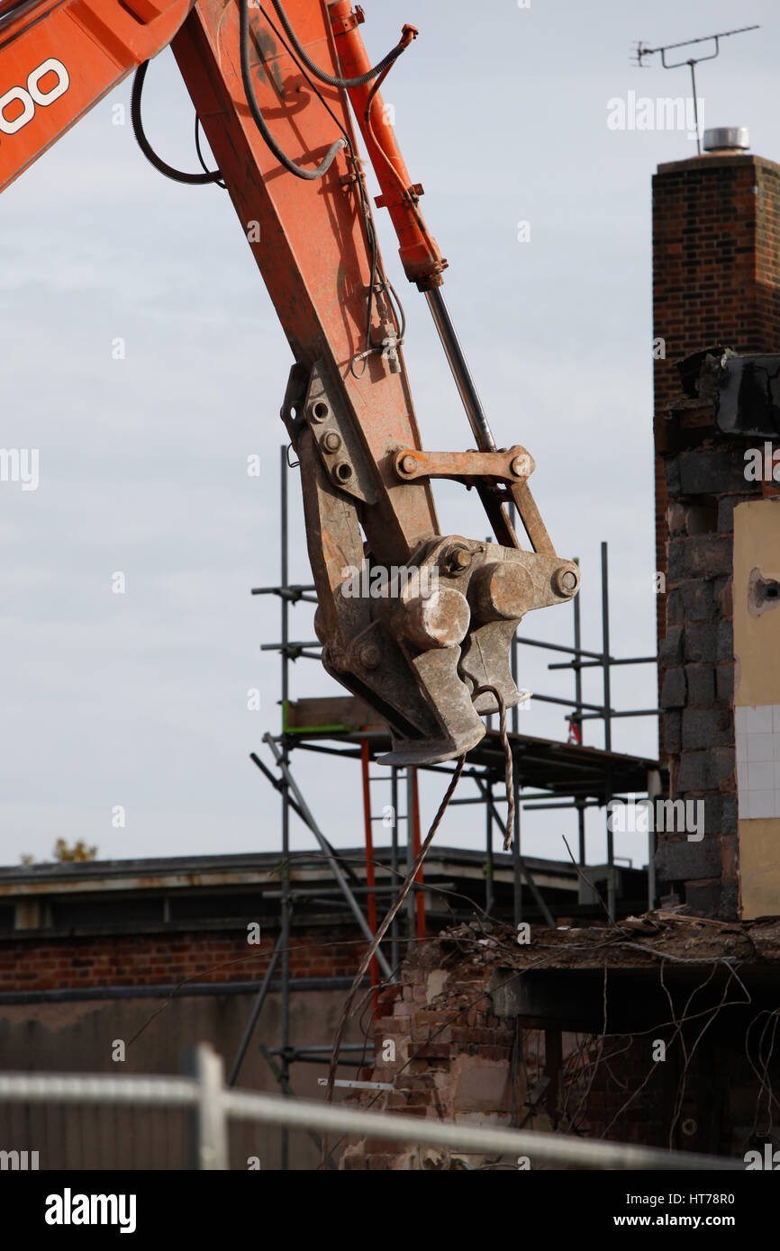 Heavy machinery at work on a demolition site. Tearing down old shops ...