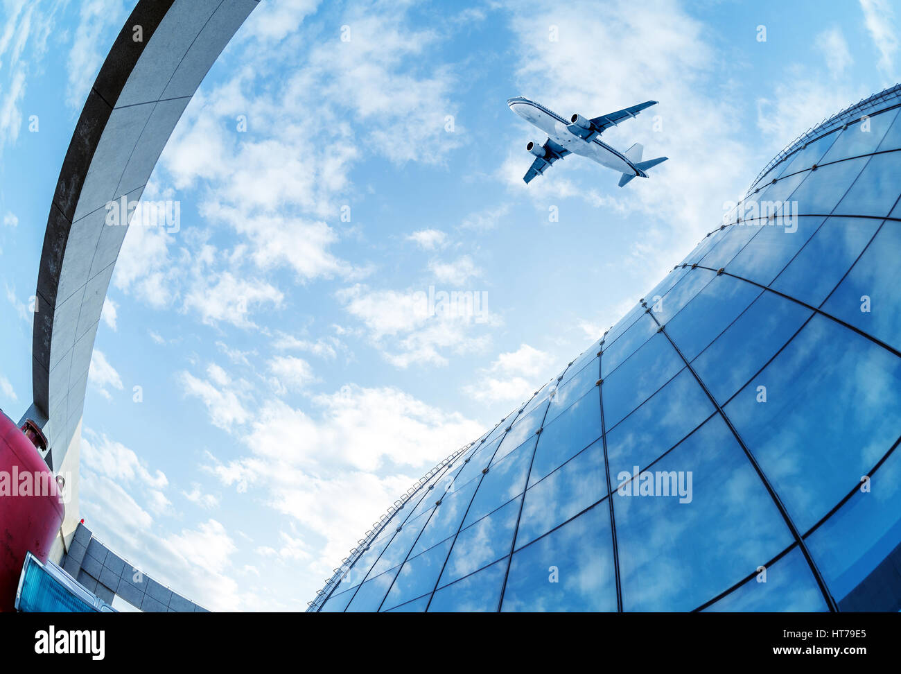 Shot of airplane flying above glass office buildings. Fisheye lens ...