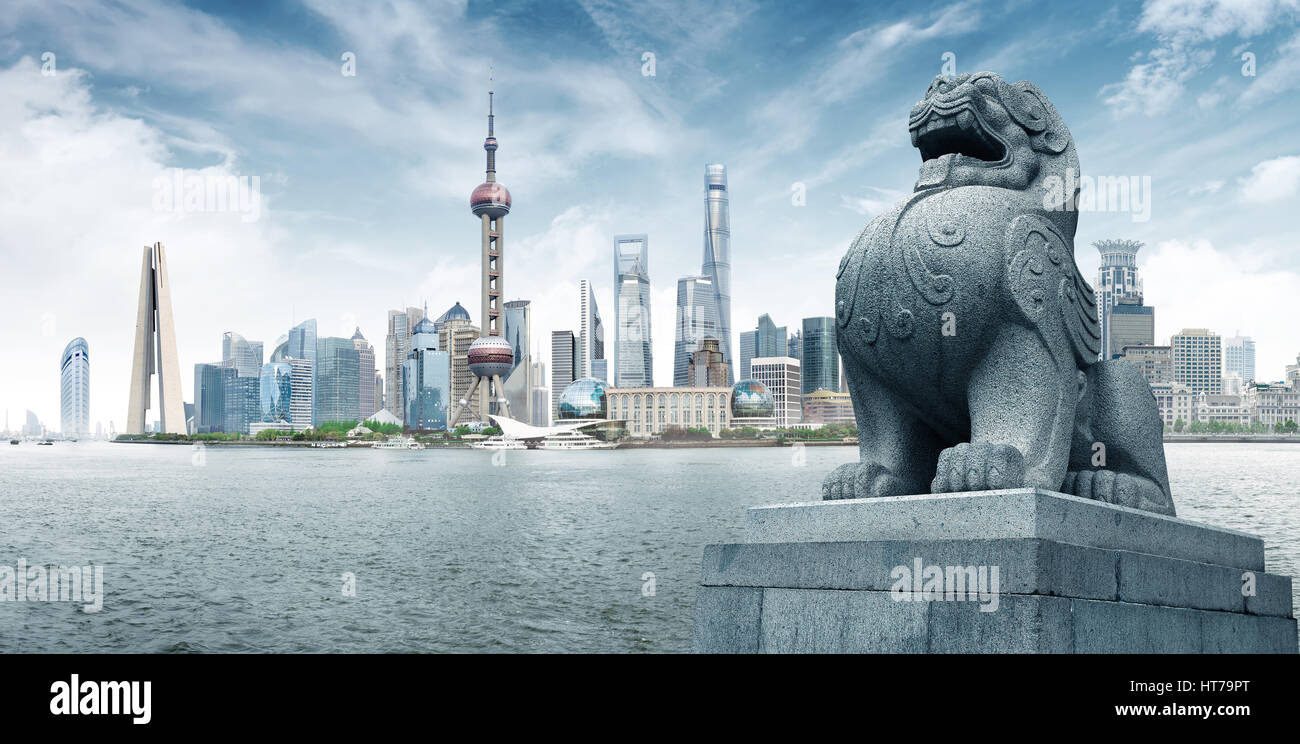 Stone lions and the city skyline in front of the city of Shanghai ...