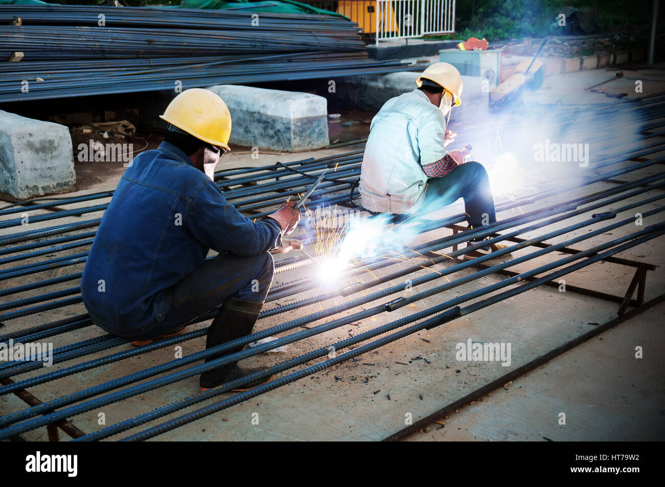 welder worker welding metal by electrode with bright electric arc and ...
