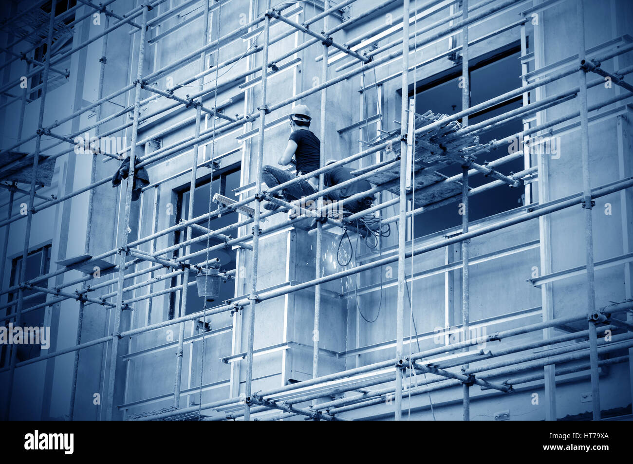 Workers at the construction site in the high-altitude scaffolding ...