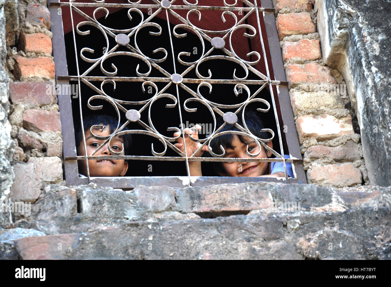 Kids smiling, home, window watching outside, Delhi, (Copyright © Saji ...