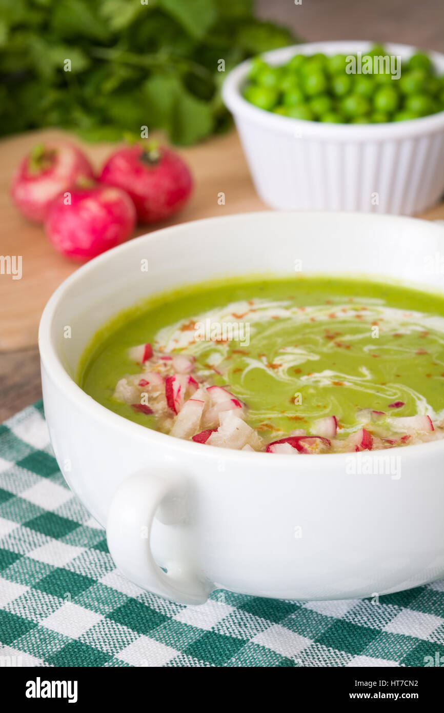 Peas cream with radishes on rustic wood Stock Photo - Alamy