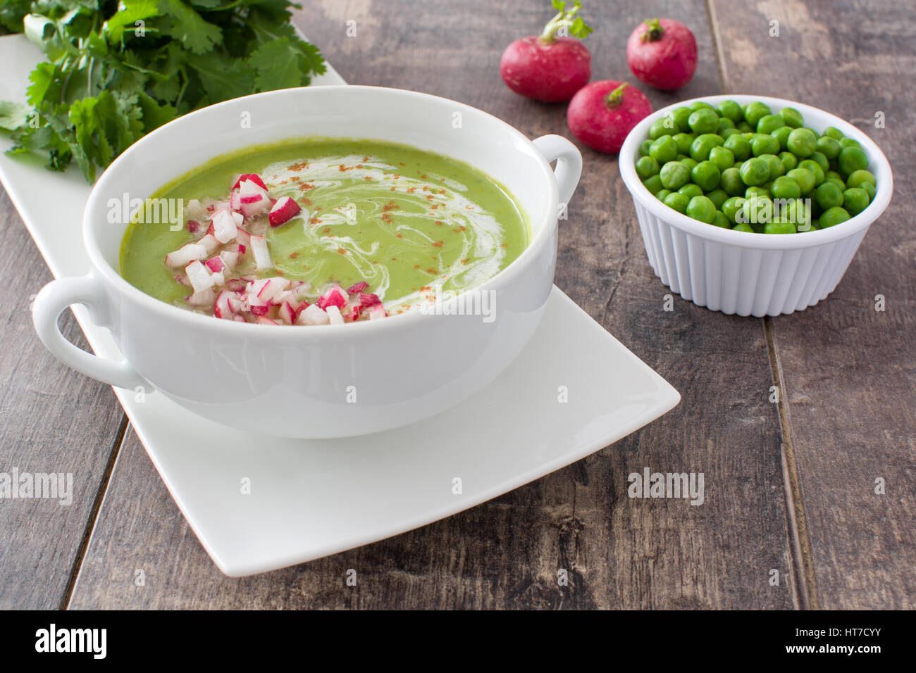 Peas cream with radishes on rustic wooden table Stock Photo - Alamy