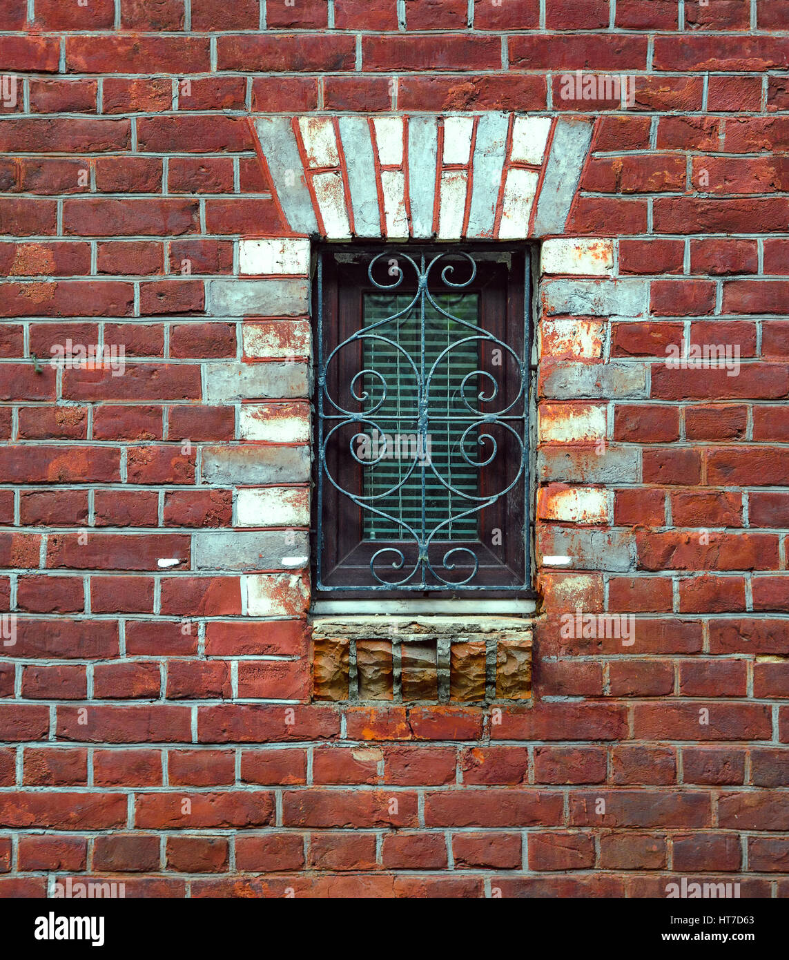 Window in brick wall. Skillful framing of window hole. Wrought iron ...