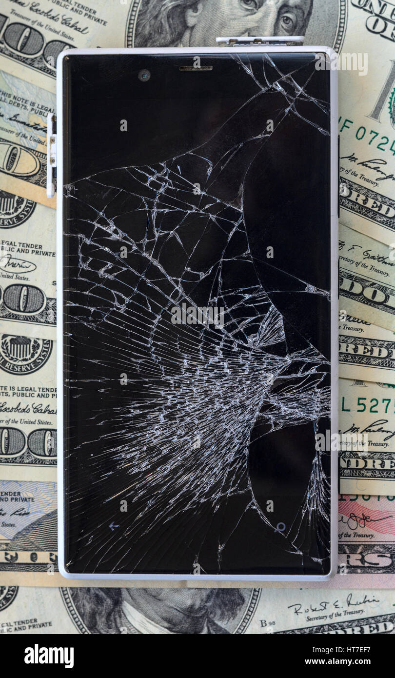 Smartphone with broken displayon money background. Loss of money ...