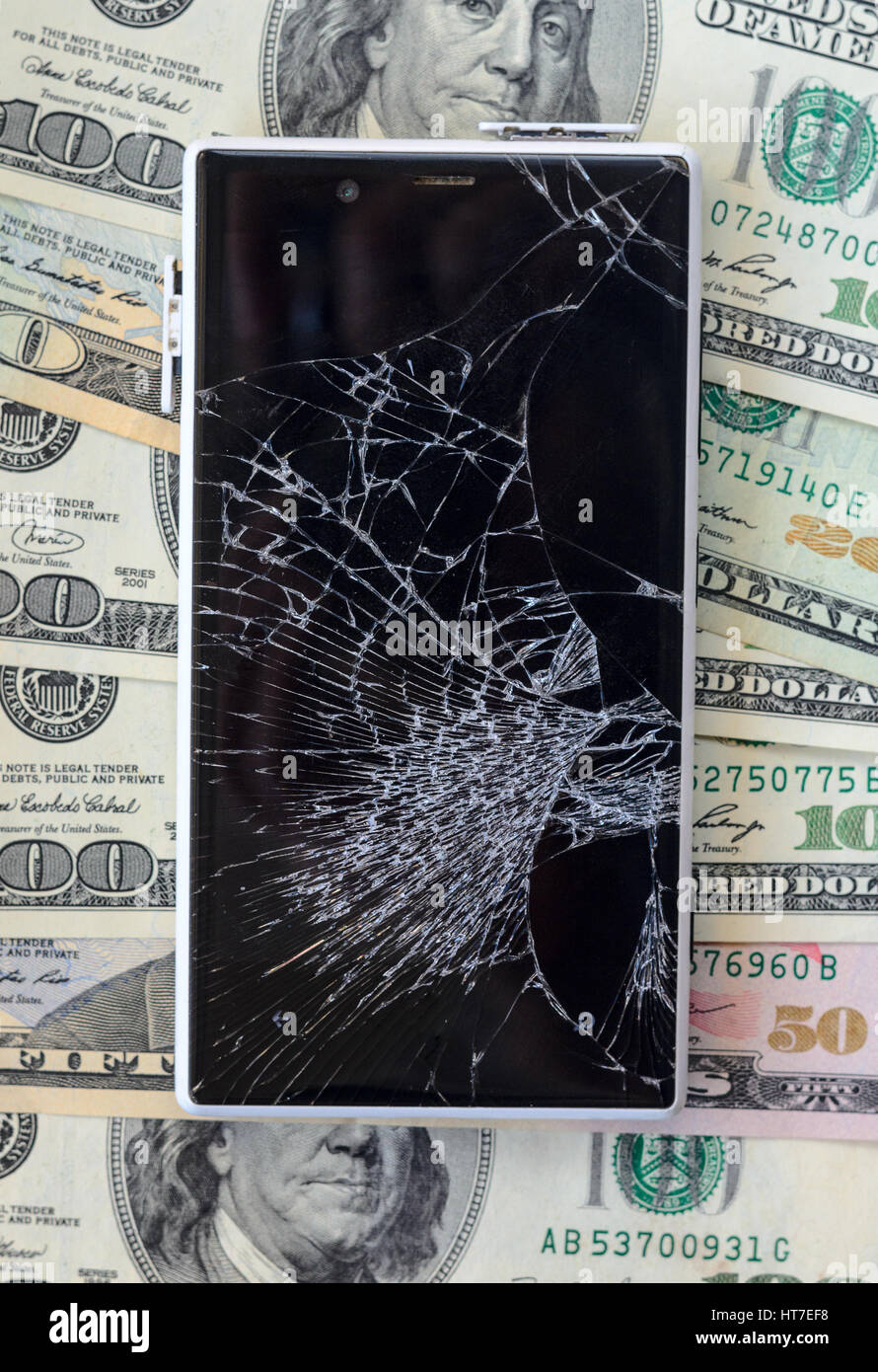 Smartphone with broken displayon money background. Loss of money ...
