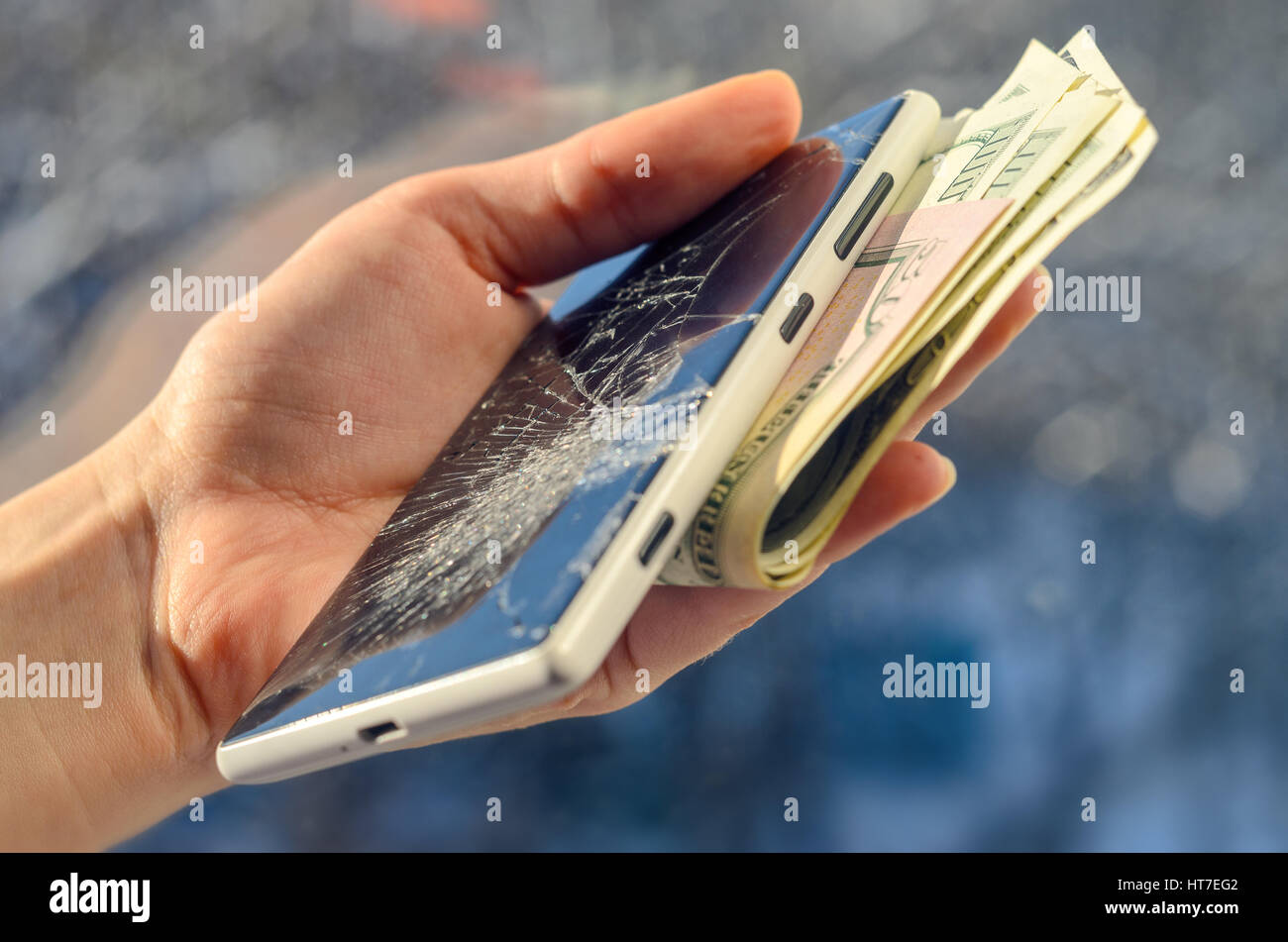 White Smartphone with broken screen in human hands on blured nature ...