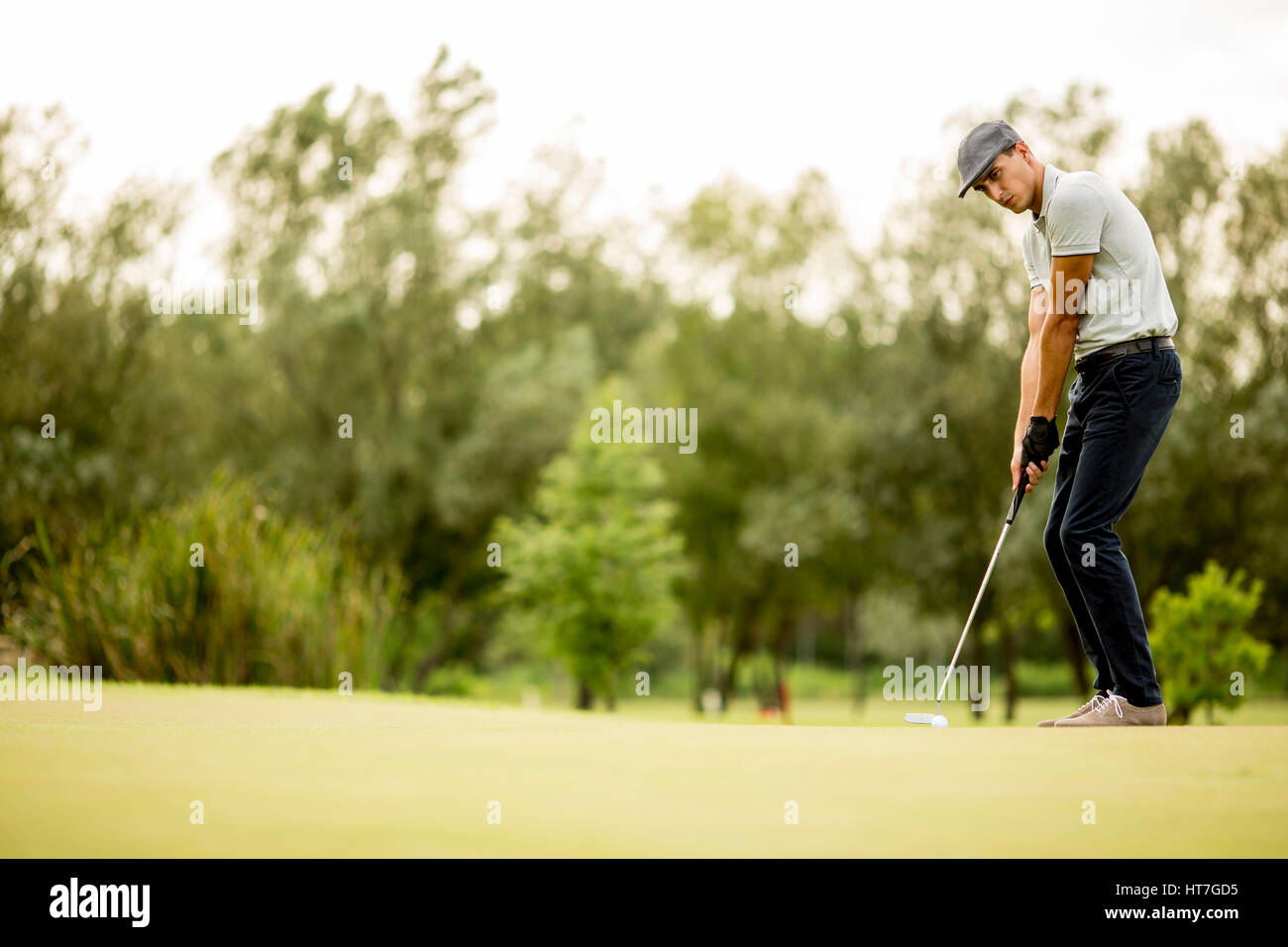 Young man playing golf on the golf course Stock Photo - Alamy
