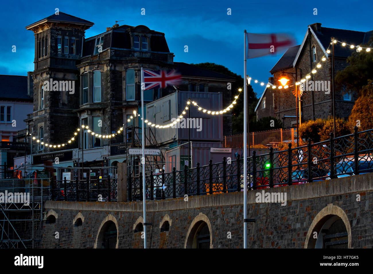 Clevedon pier seafront at dusk with flags flying and lights on Stock ...