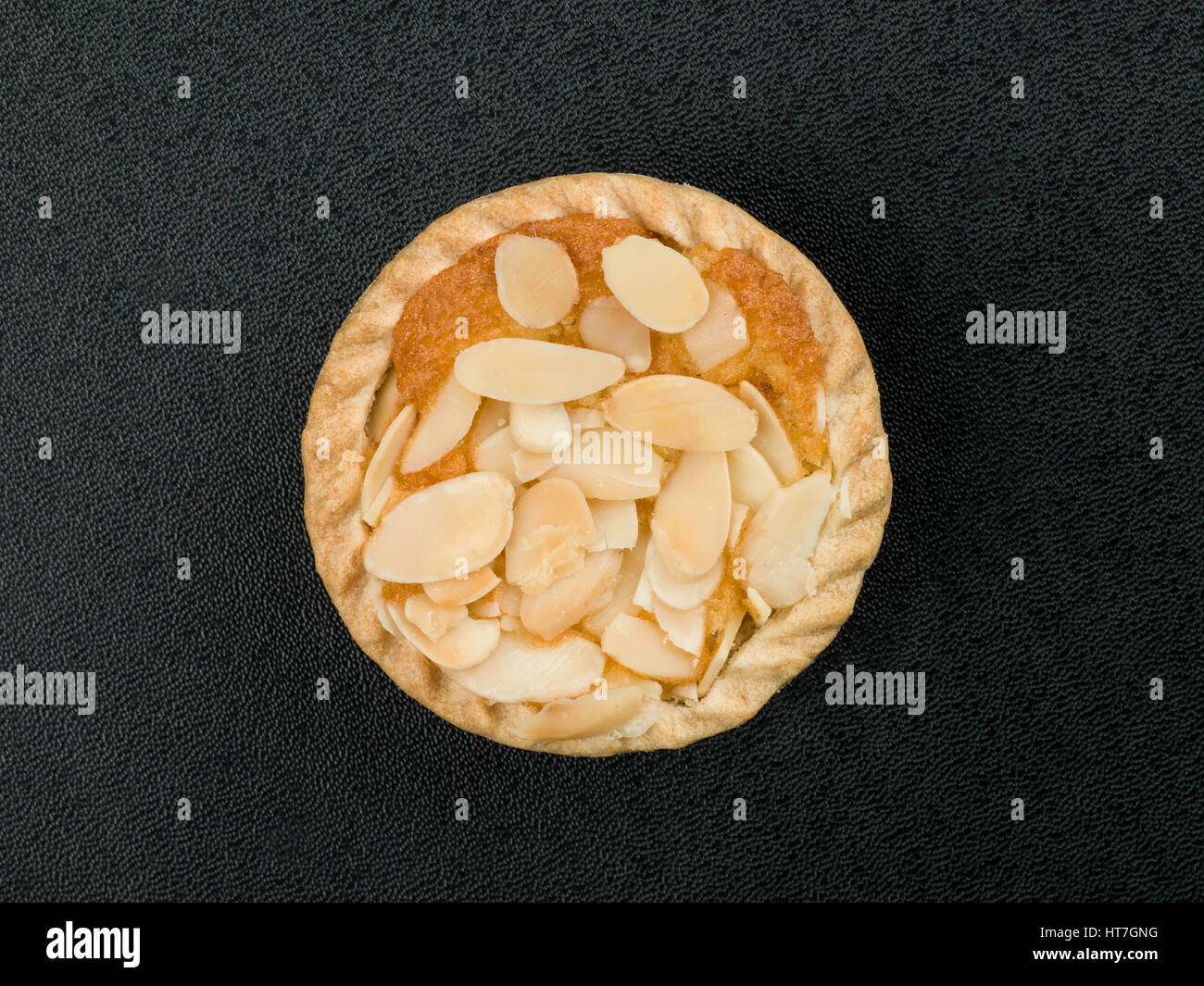 Individual Almond Topped Bakewell Tart Against a Black Background Stock ...